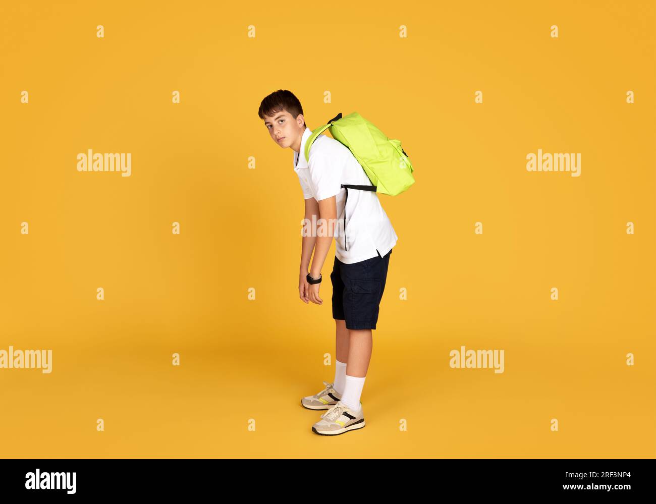 Unhappy tired caucasian teenager boy pupil with big heavy backpack ...