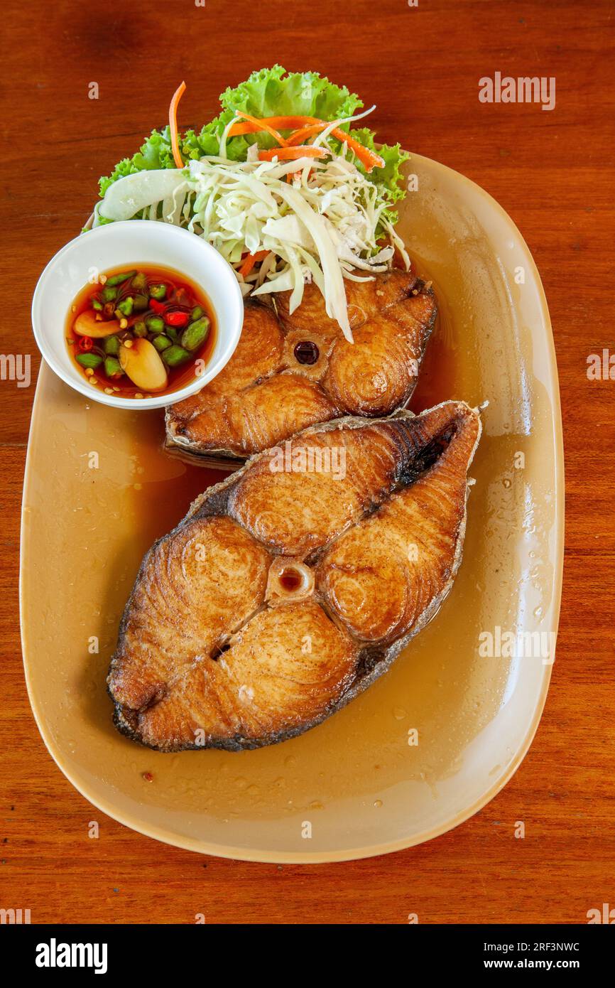 Deep Fried Mackerel with Fish Sauce on plate with wooden table ...