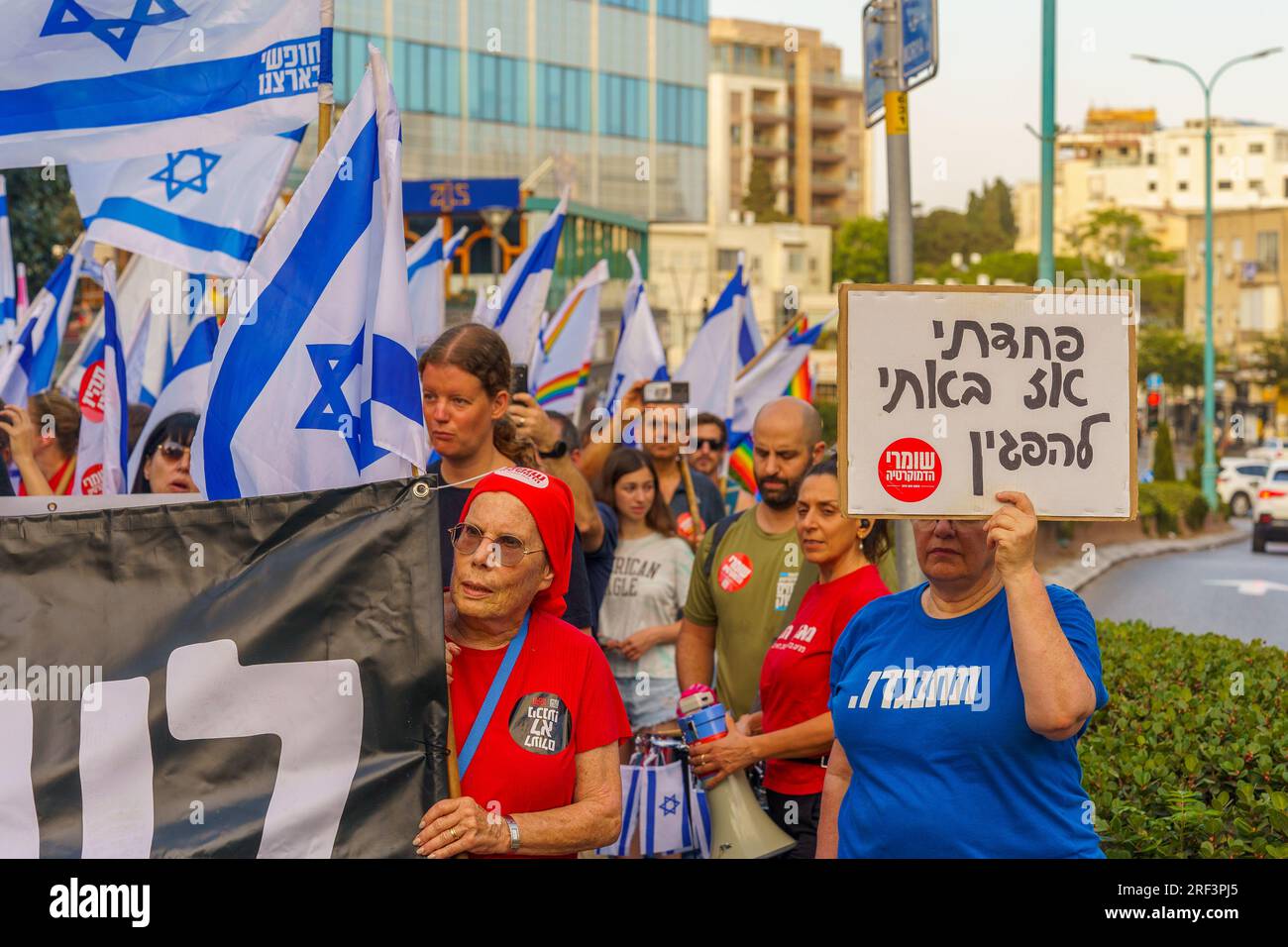 Haifa, Israel - July 29, 2023: People march with various signs under ...