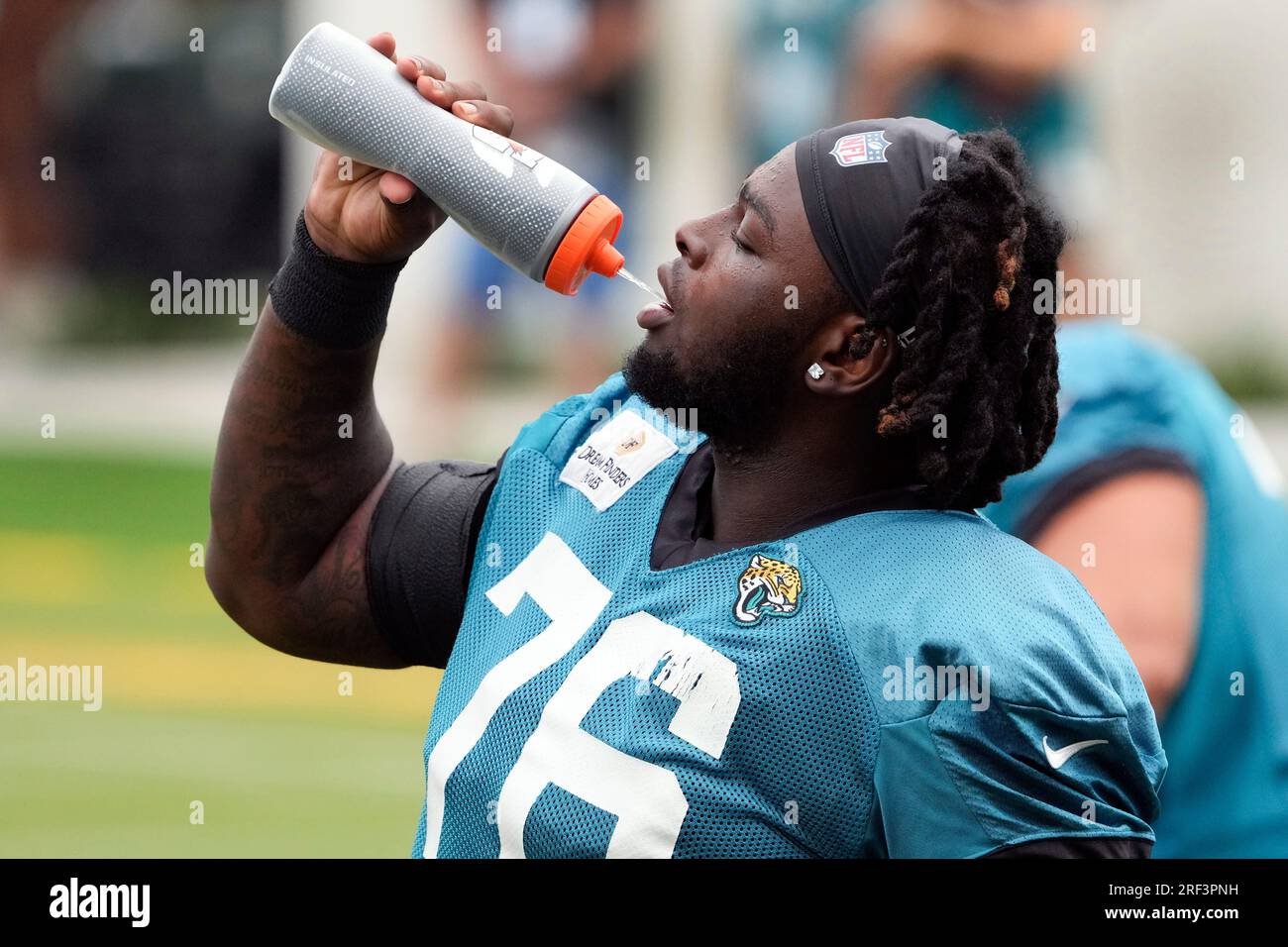 Jacksonville Jaguars offensive tackle Anton Harrison (76) takes a water ...