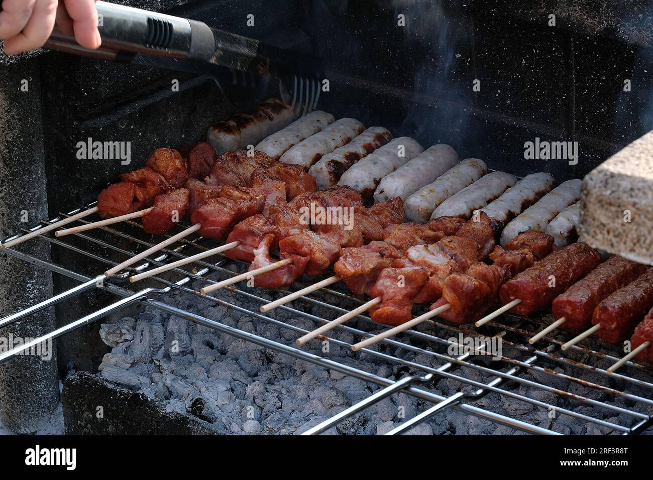 Purpose built stone and brick barbecue in use in house garden. UK Stock ...
