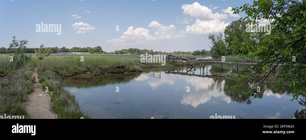 landscape with rundown piers of fluvial harbor on Quaranta canal banks ...