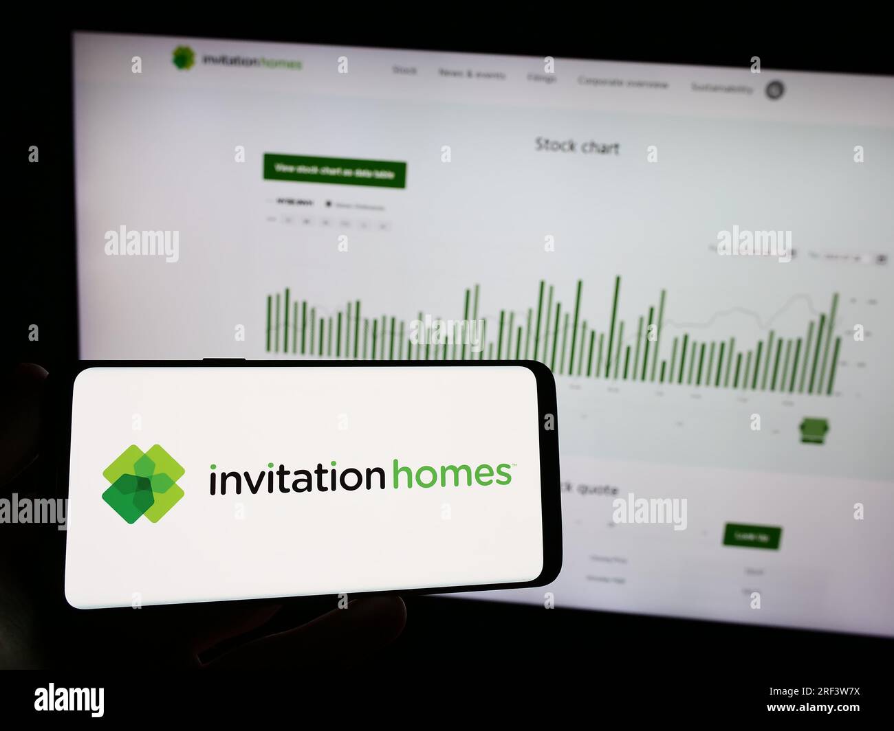 Person holding mobile phone with logo of US real estate company ...