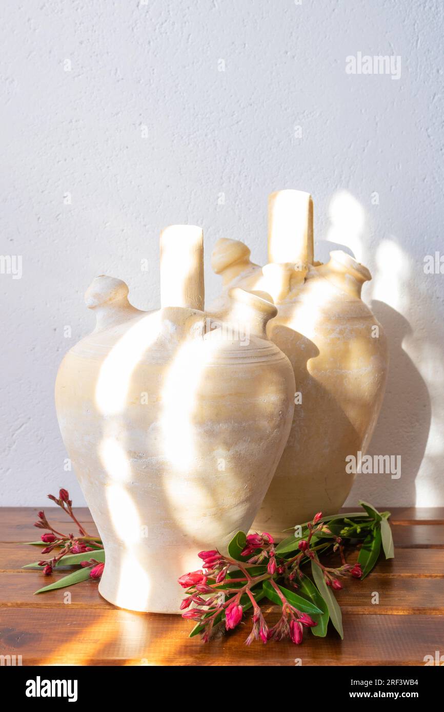 two botijos on wooden planks on white textured wall background with ...