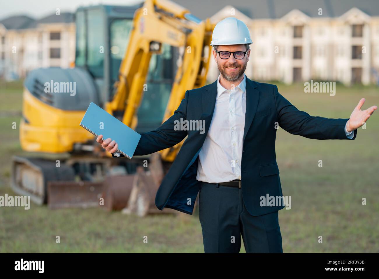 Construction owner near excavator. Confident construction owner in ...