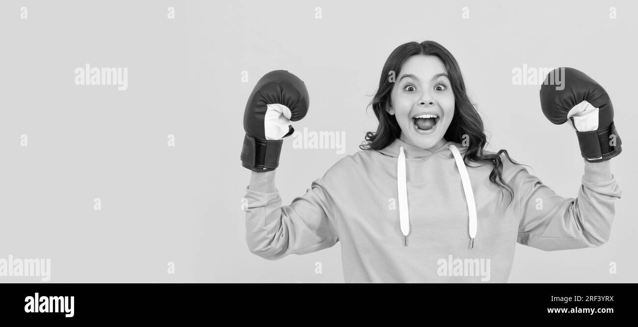 surprised child in boxing gloves on yellow background. Horizontal ...