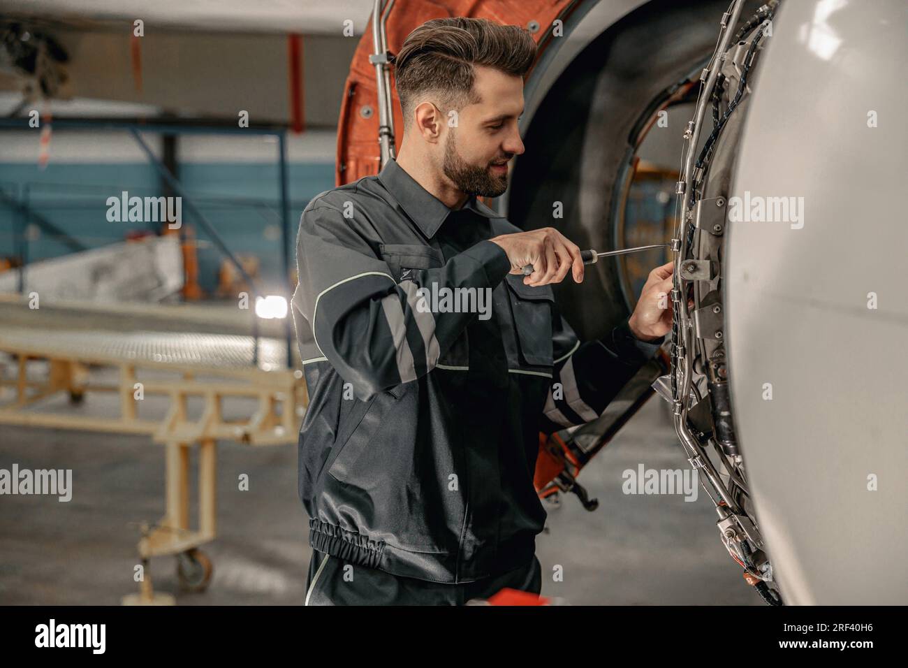 Male aviation mechanic repairing aircraft in hangar Stock Photo - Alamy