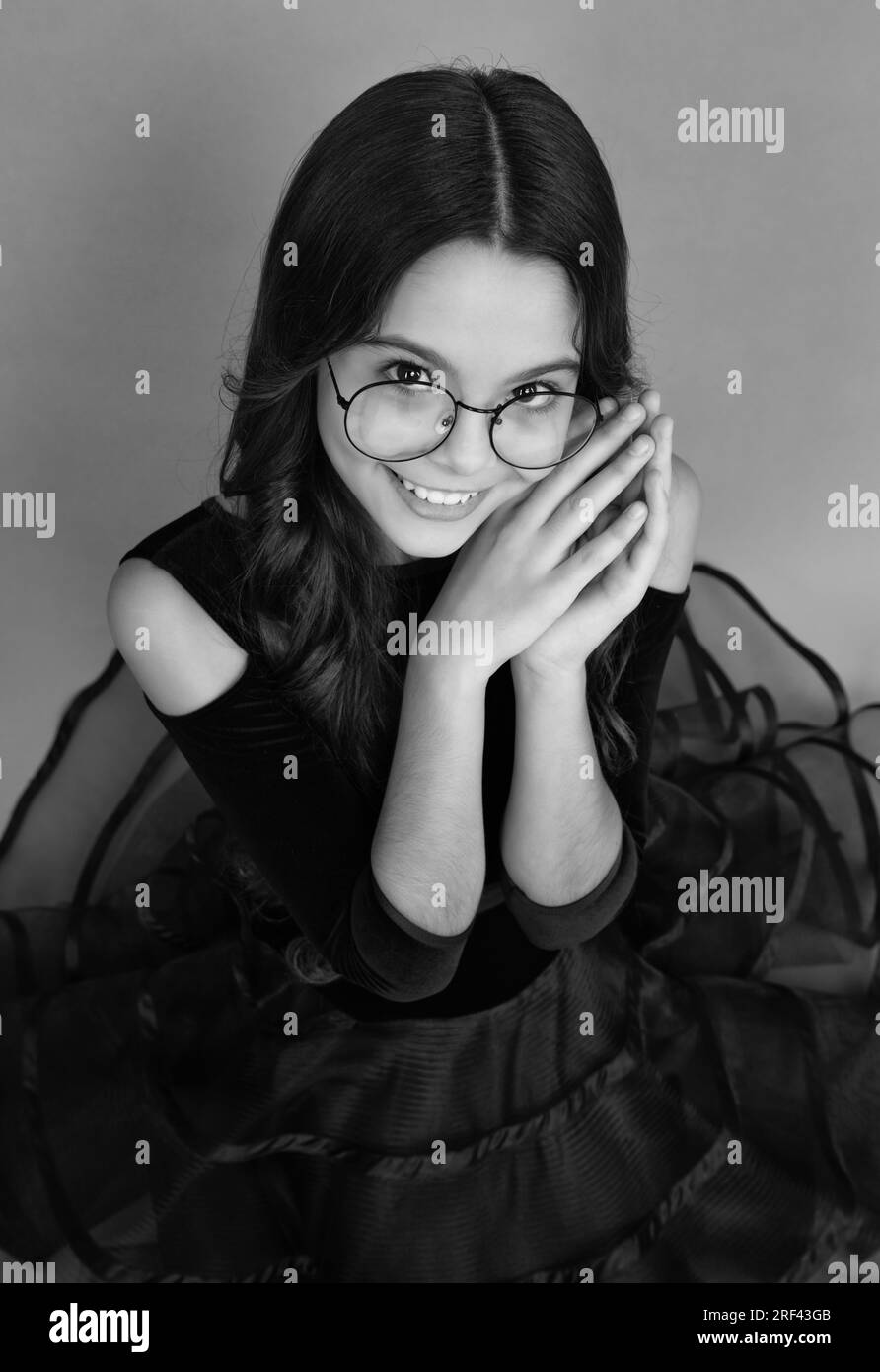 Cute face of teenager girl. Children studio portrait on gray ow ...