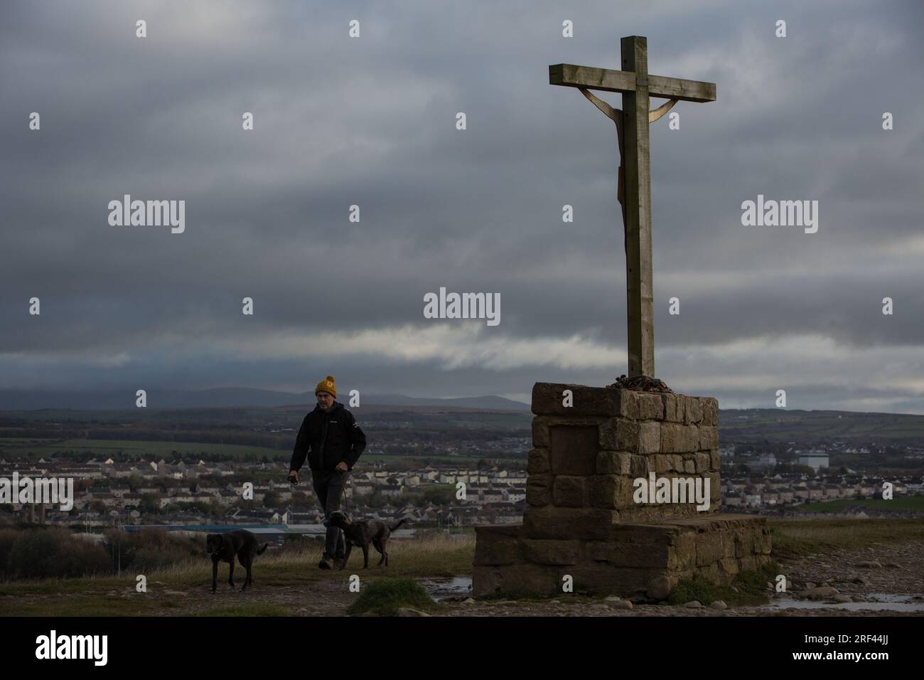 View of the town with crucifix on plinth on coastal cliff top, in ...