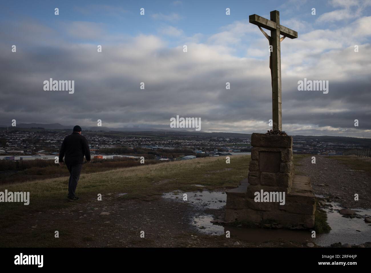 View of the town with crucifix on plinth on coastal cliff top, in ...