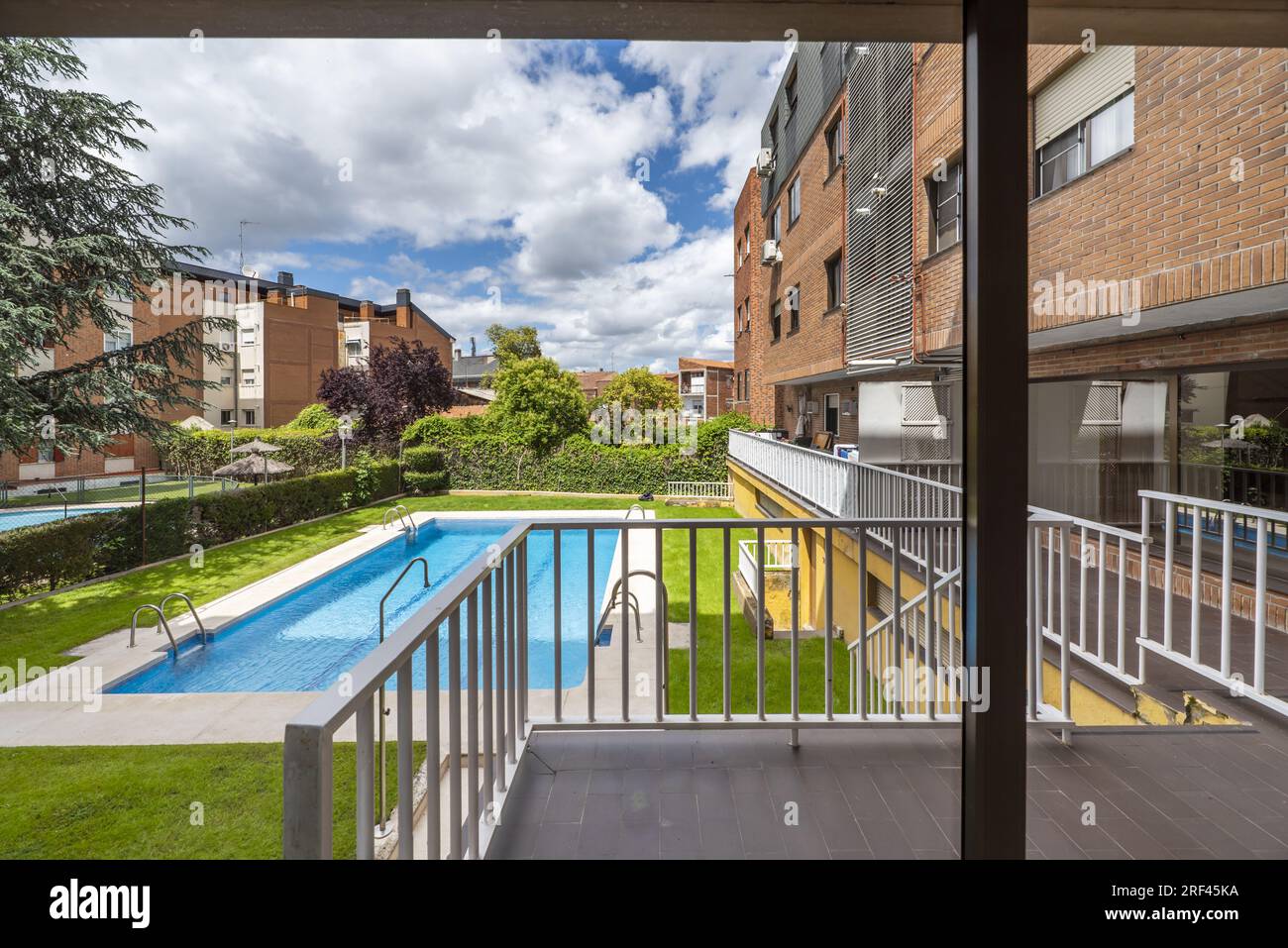 Common areas of an urbanization with a lot of green grass next to a ...