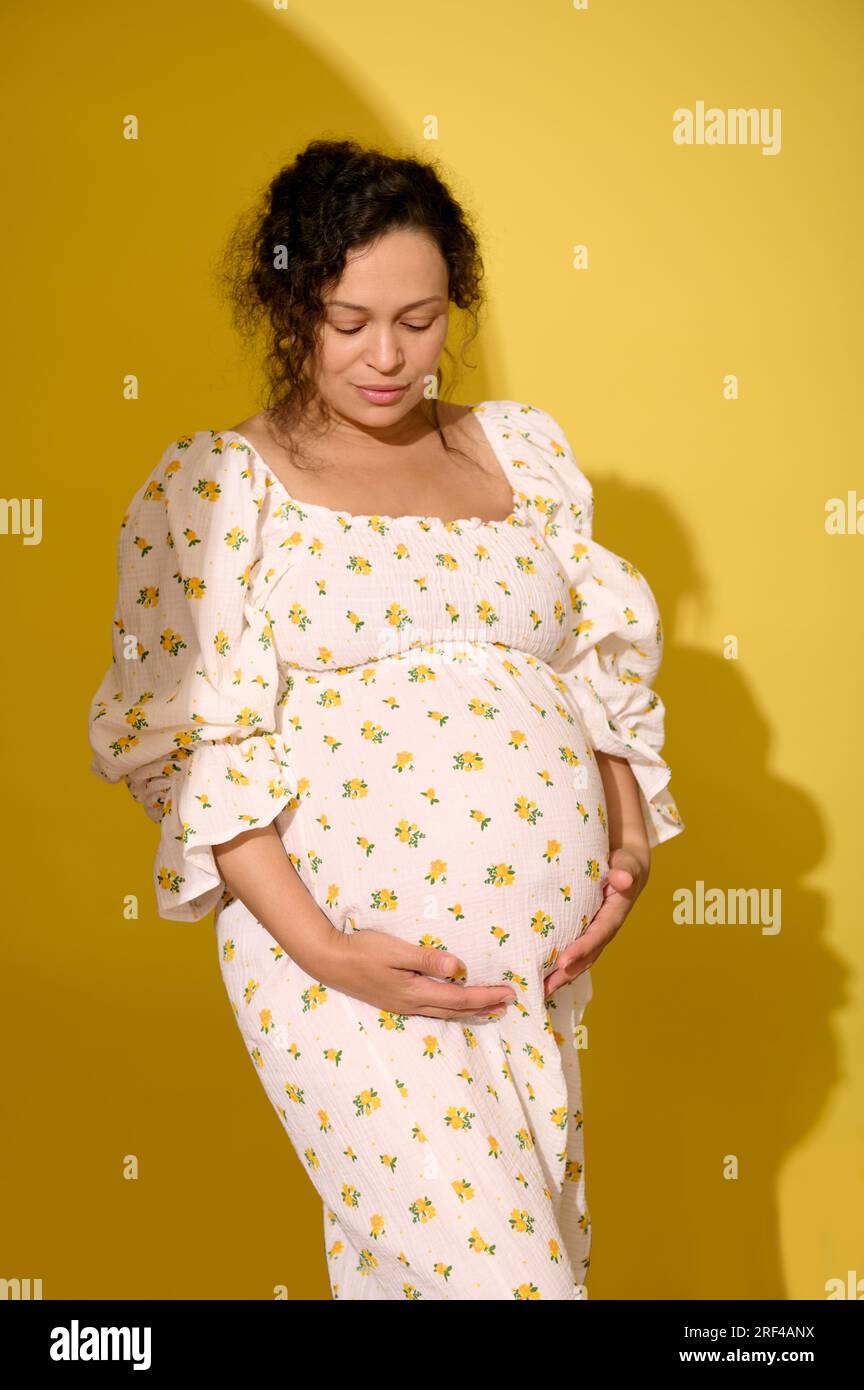 Multi-ethnic curly haired middle aged pregnant woman, gravid expectant ...