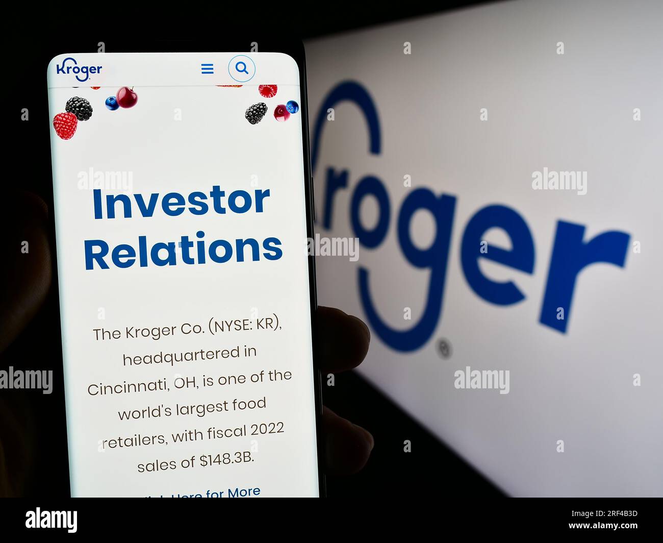 Person holding mobile phone with web page of US retail business The ...