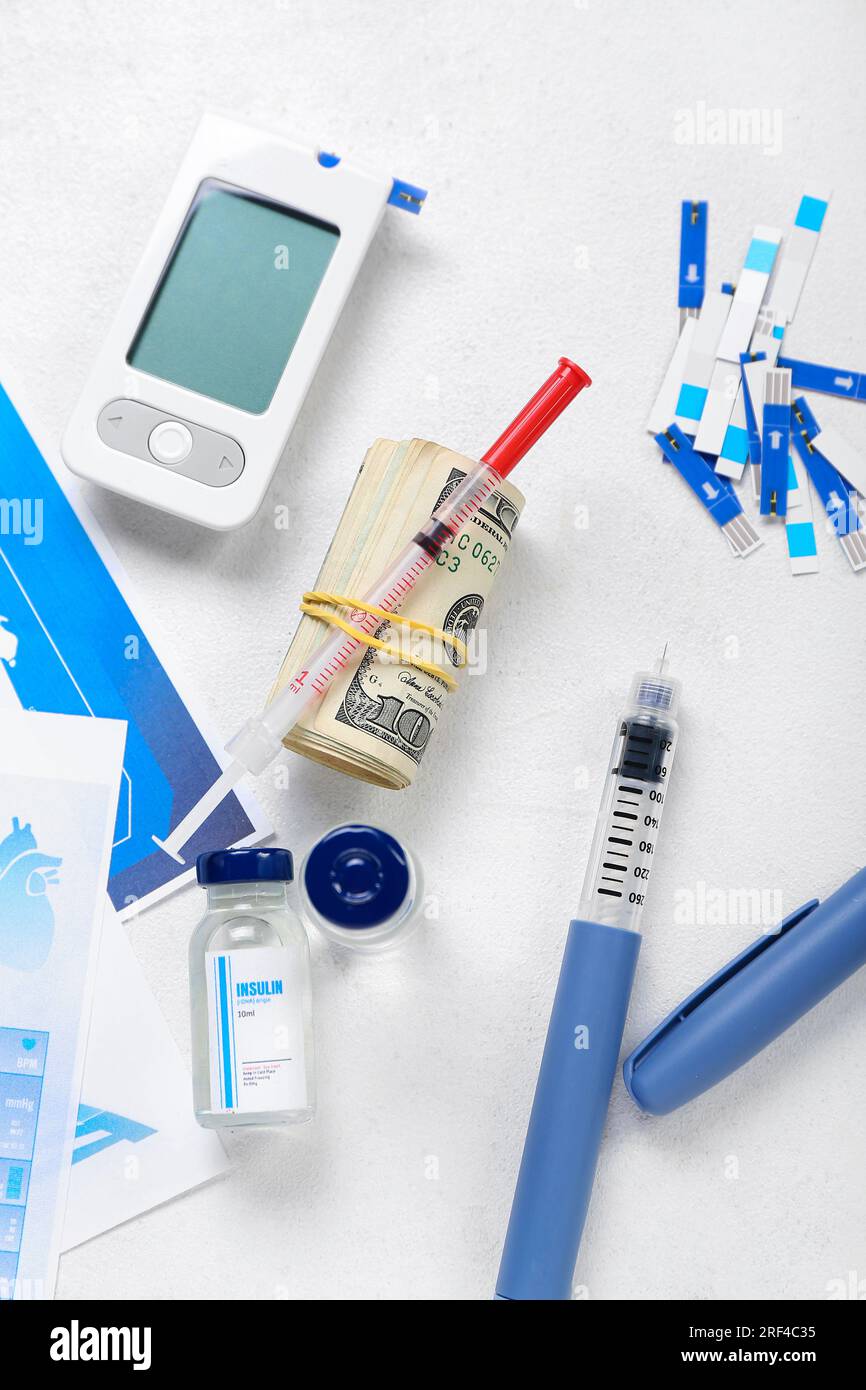 Money and medical supplies for patient with diabetes on white ...