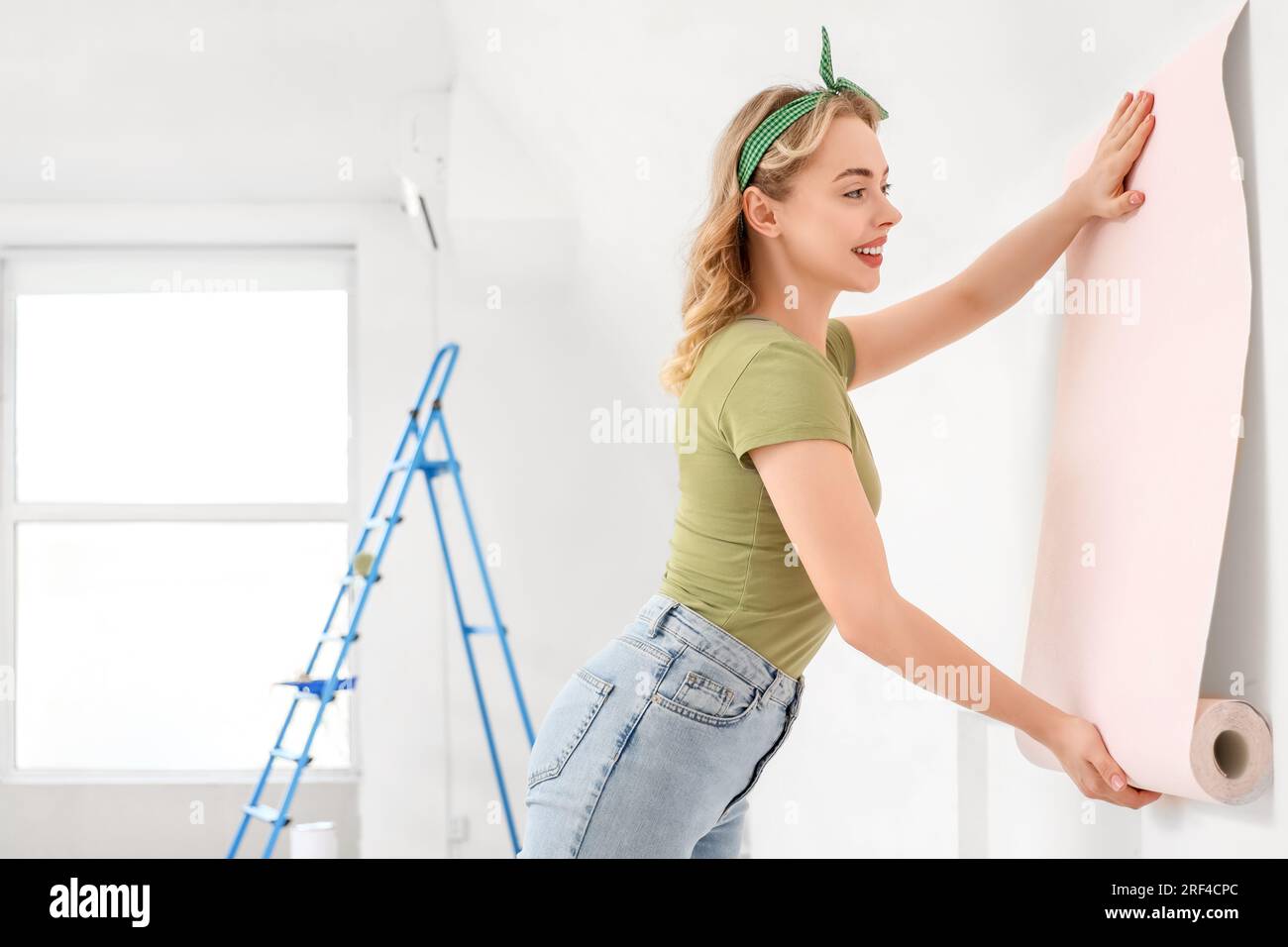 Young woman with wallpaper roll at home Stock Photo - Alamy