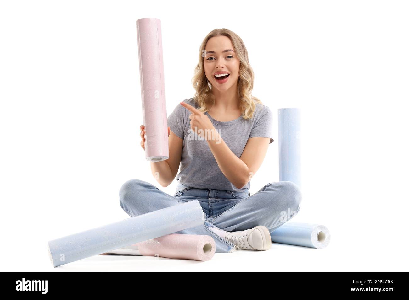Young woman pointing at wallpaper roll on white background Stock Photo ...