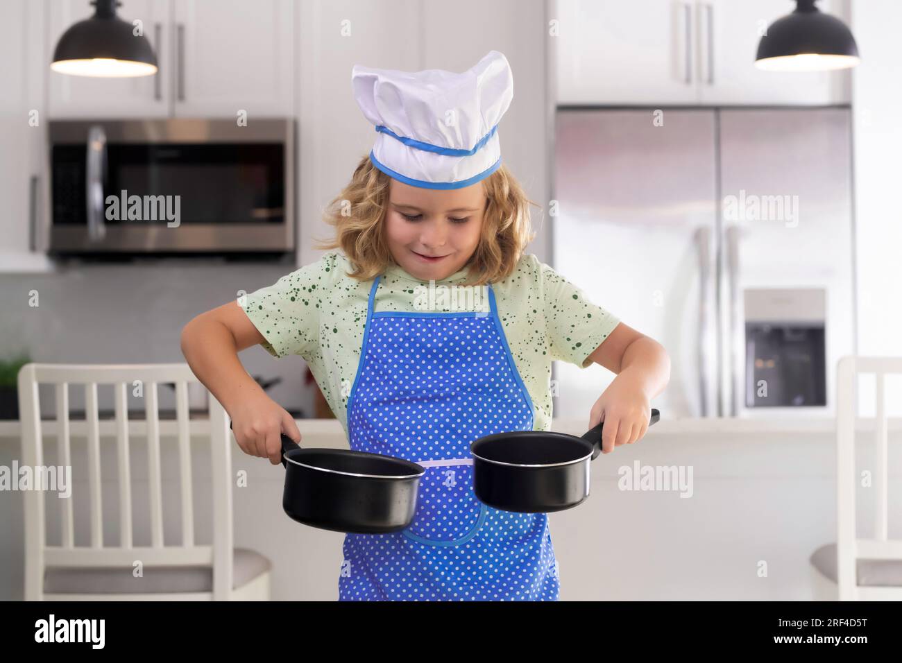 Children cooking in the kitchen. Funny kid chef cook cookery at kitchen ...