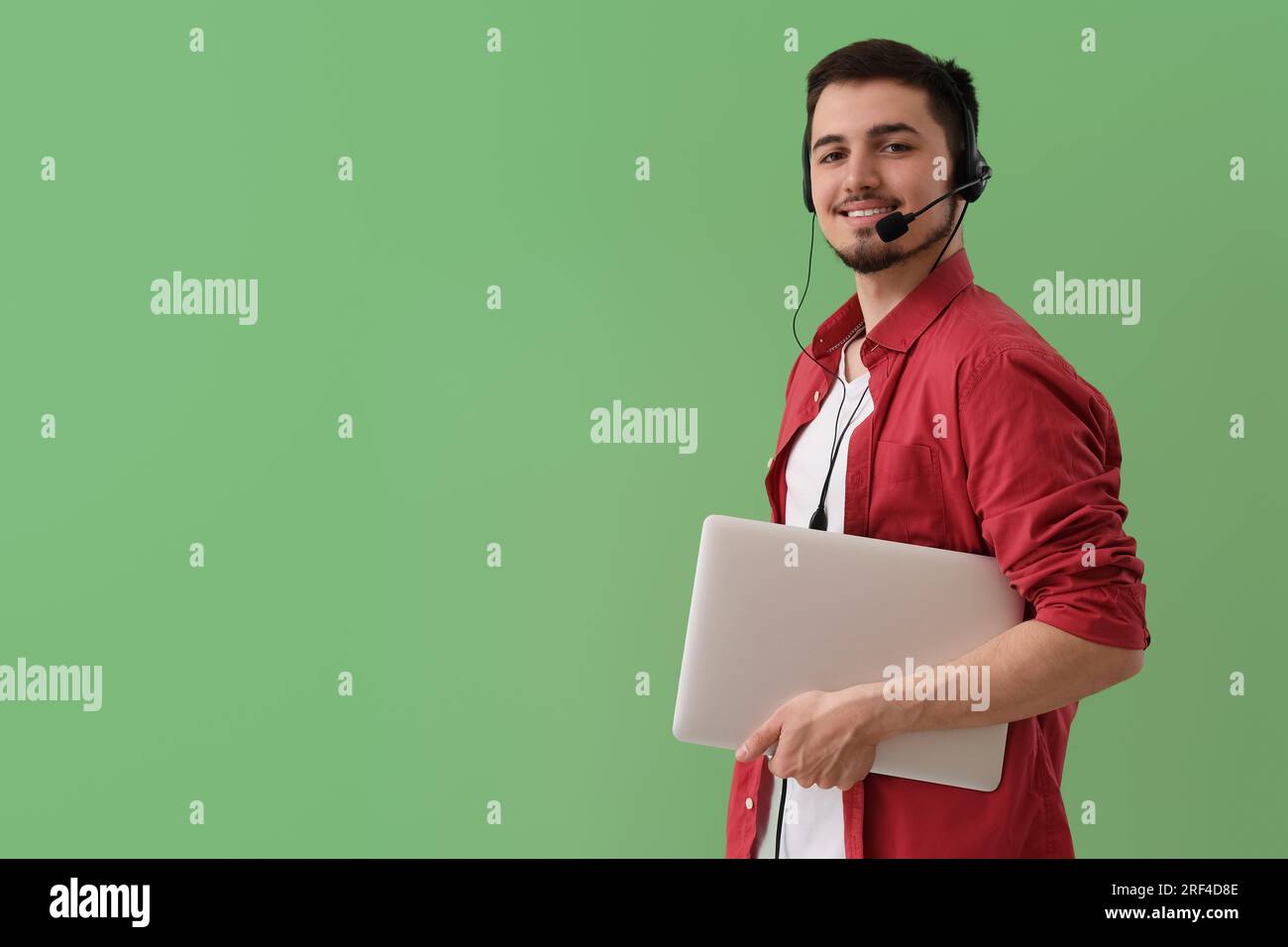 Male technical support agent with laptop on green background Stock ...