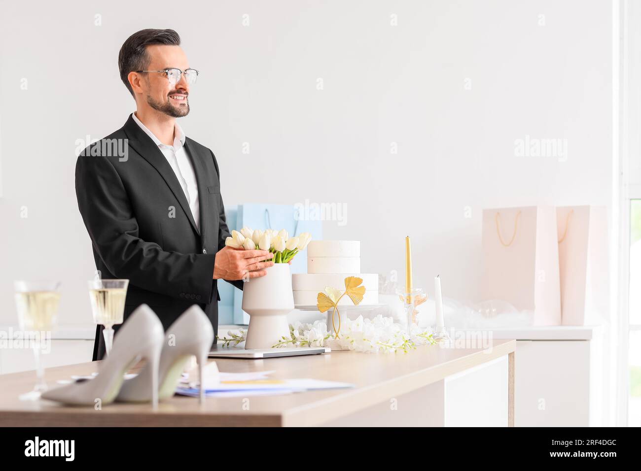 Male wedding planner with flowers in office Stock Photo - Alamy