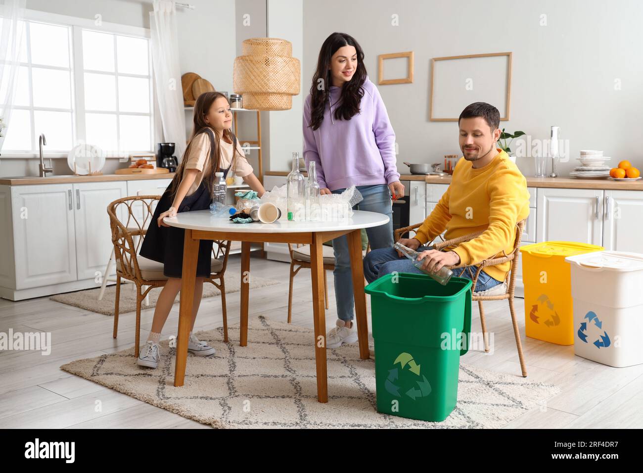 Family sorting garbage with recycle bin in kitchen Stock Photo - Alamy