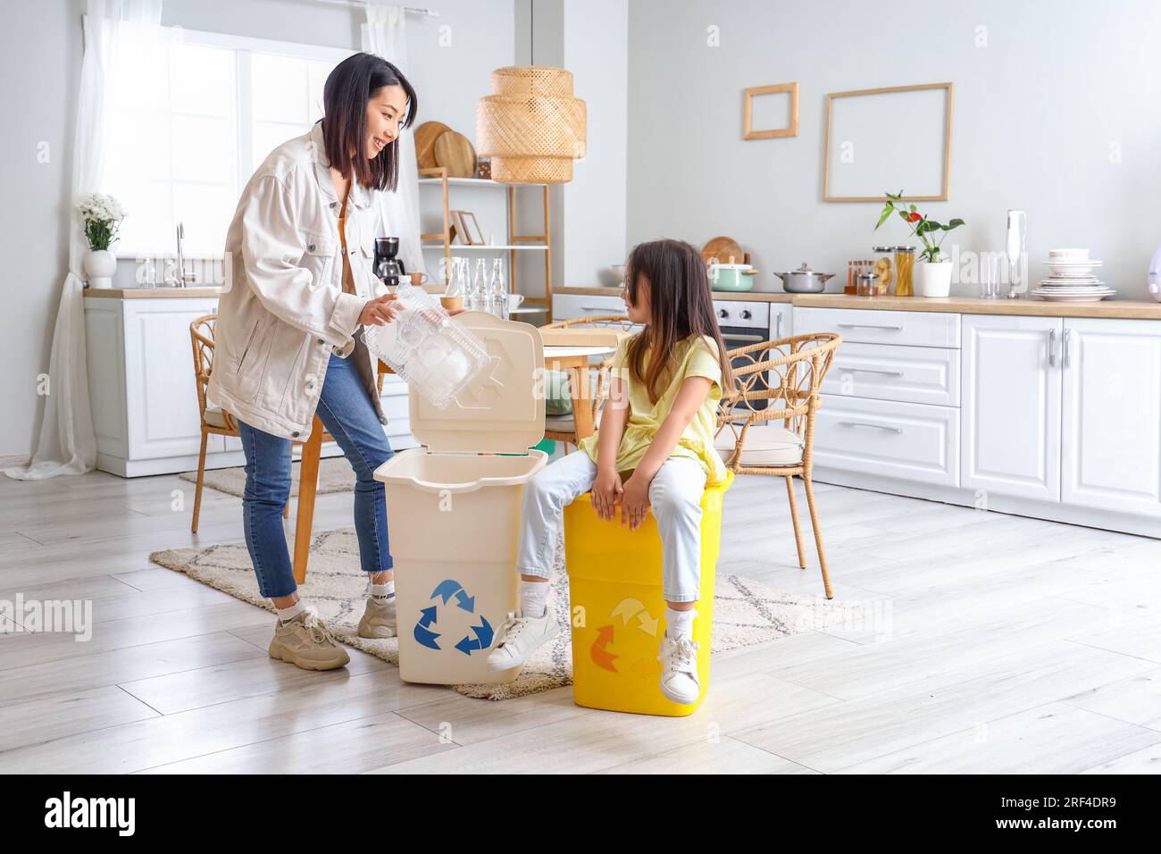 Asian mother with her little daughter throwing plastic garbage in ...