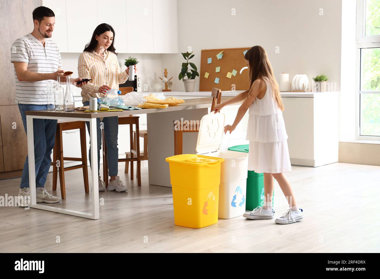 Family sorting garbage with recycle bins in kitchen Stock Photo - Alamy