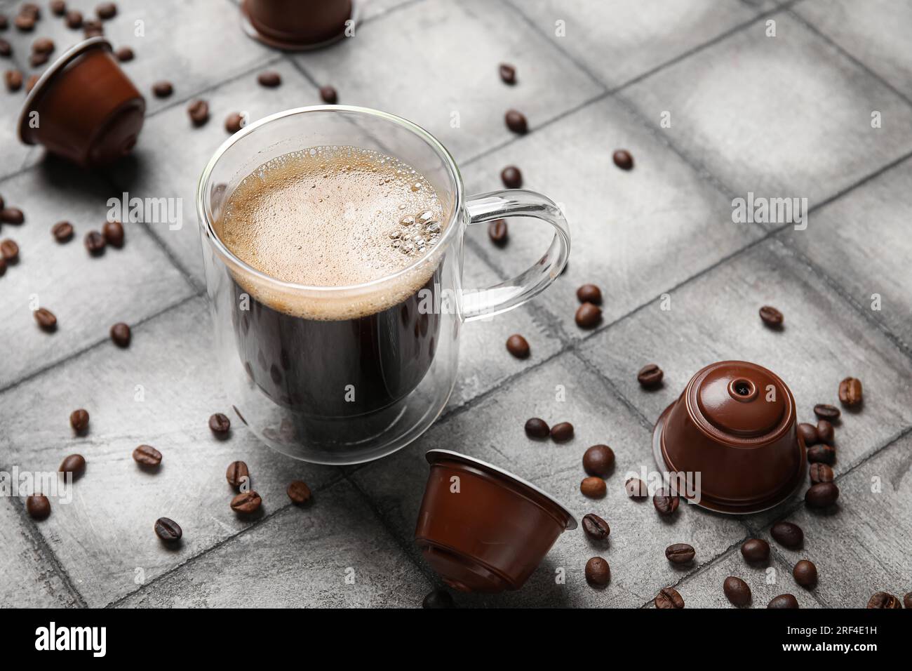 Cup of delicious espresso, pods and beans on grey grunge table Stock ...