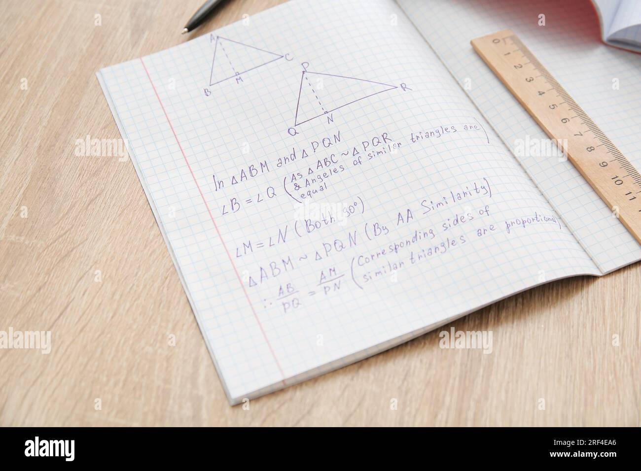 Open copybooks with math formulas and ruler on wooden table, closeup ...