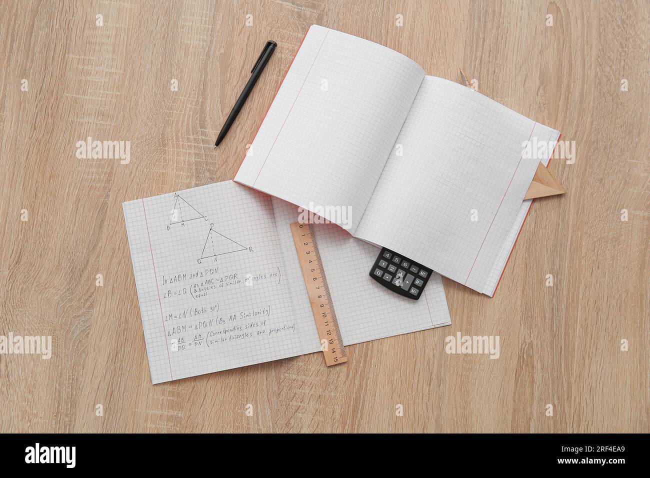Open copybooks with math formulas, ruler and calculator on wooden table ...