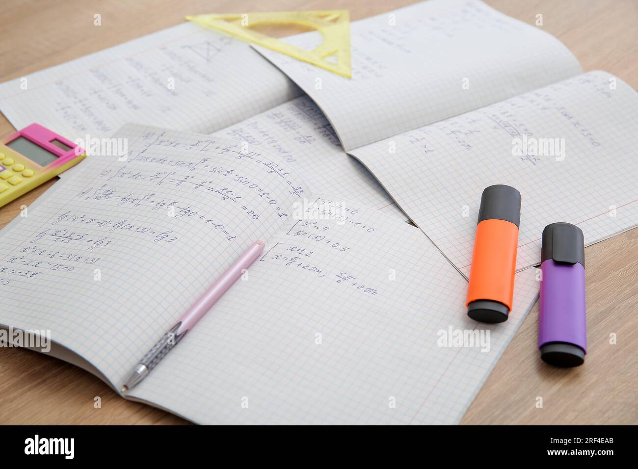 Open copybooks with math formulas and stationery on wooden table Stock ...