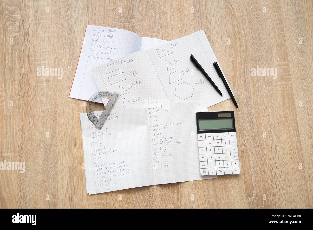 Open copybooks with math formulas and stationery on wooden table Stock ...