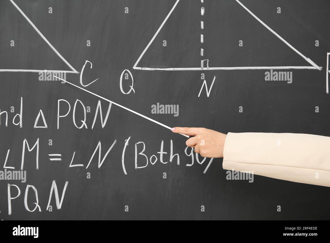 Female teacher's hand with pointer explaining math formulas on ...