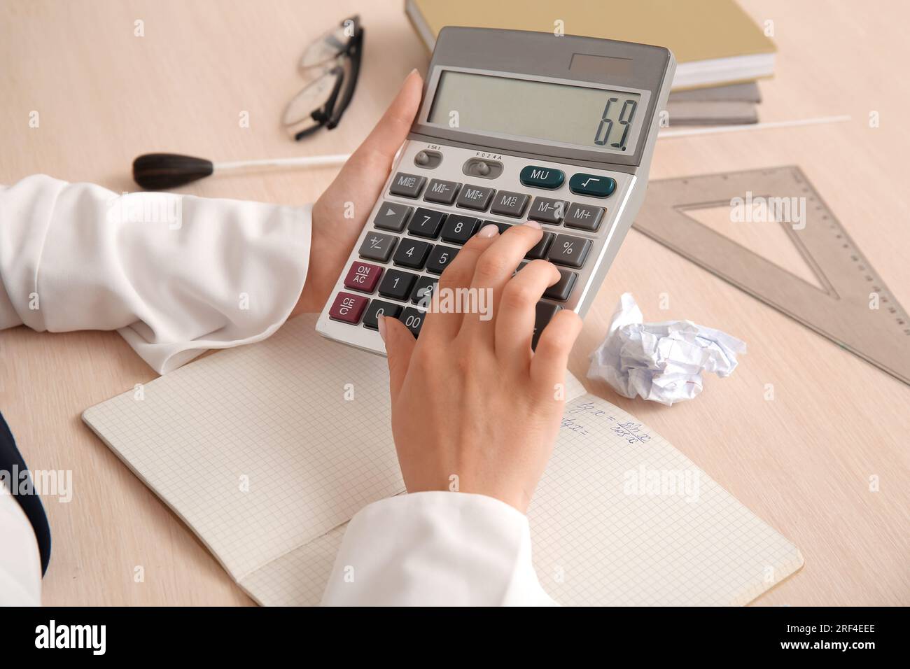 Female math teacher checking pupil's homework at wooden table, closeup ...
