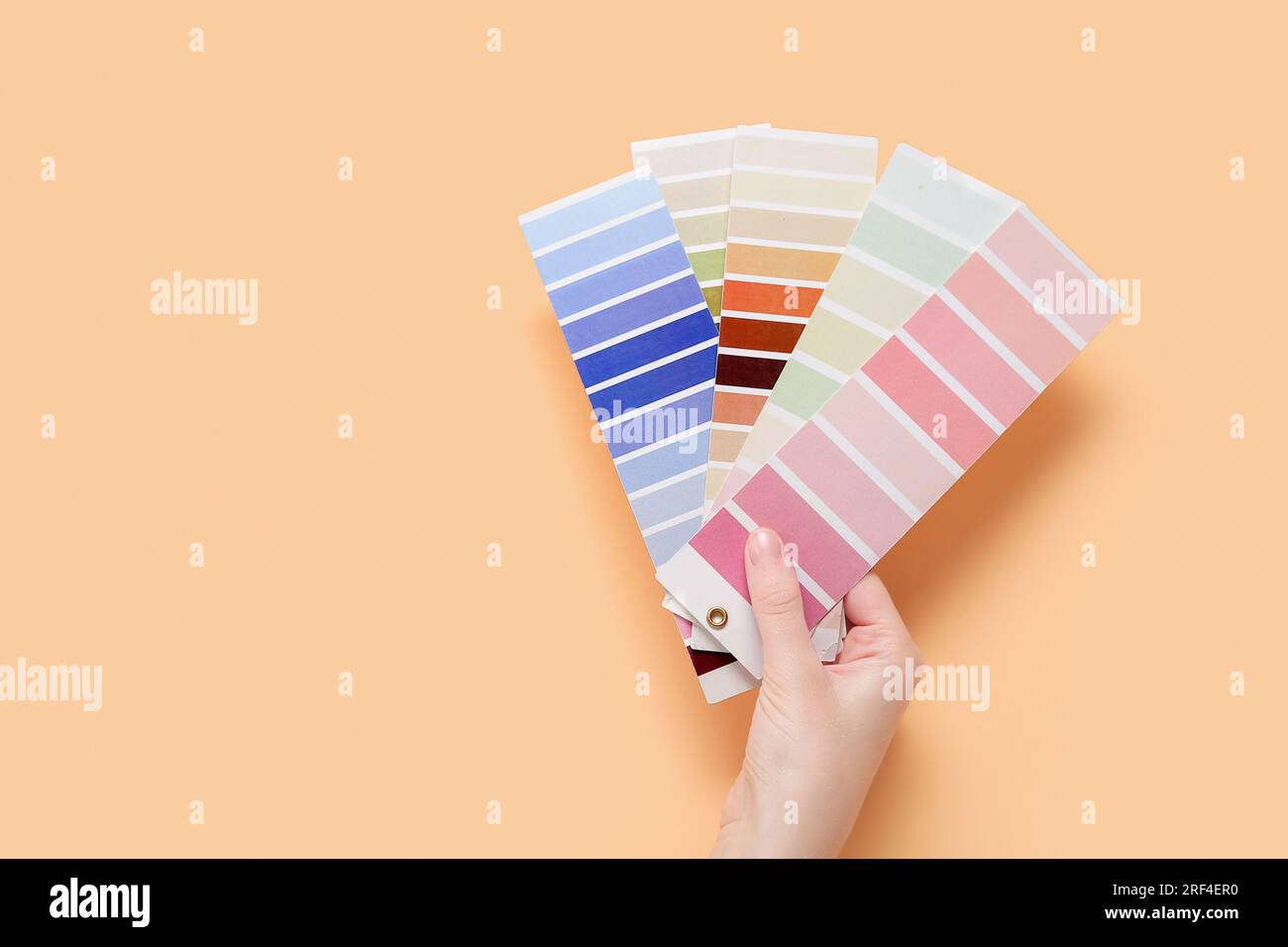 Hand with color palettes on beige background Stock Photo - Alamy
