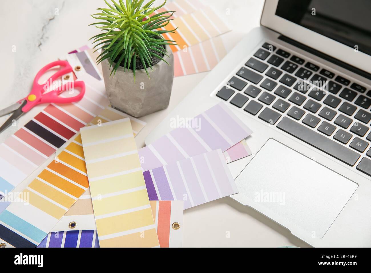 Many color palettes and laptop on light background Stock Photo - Alamy