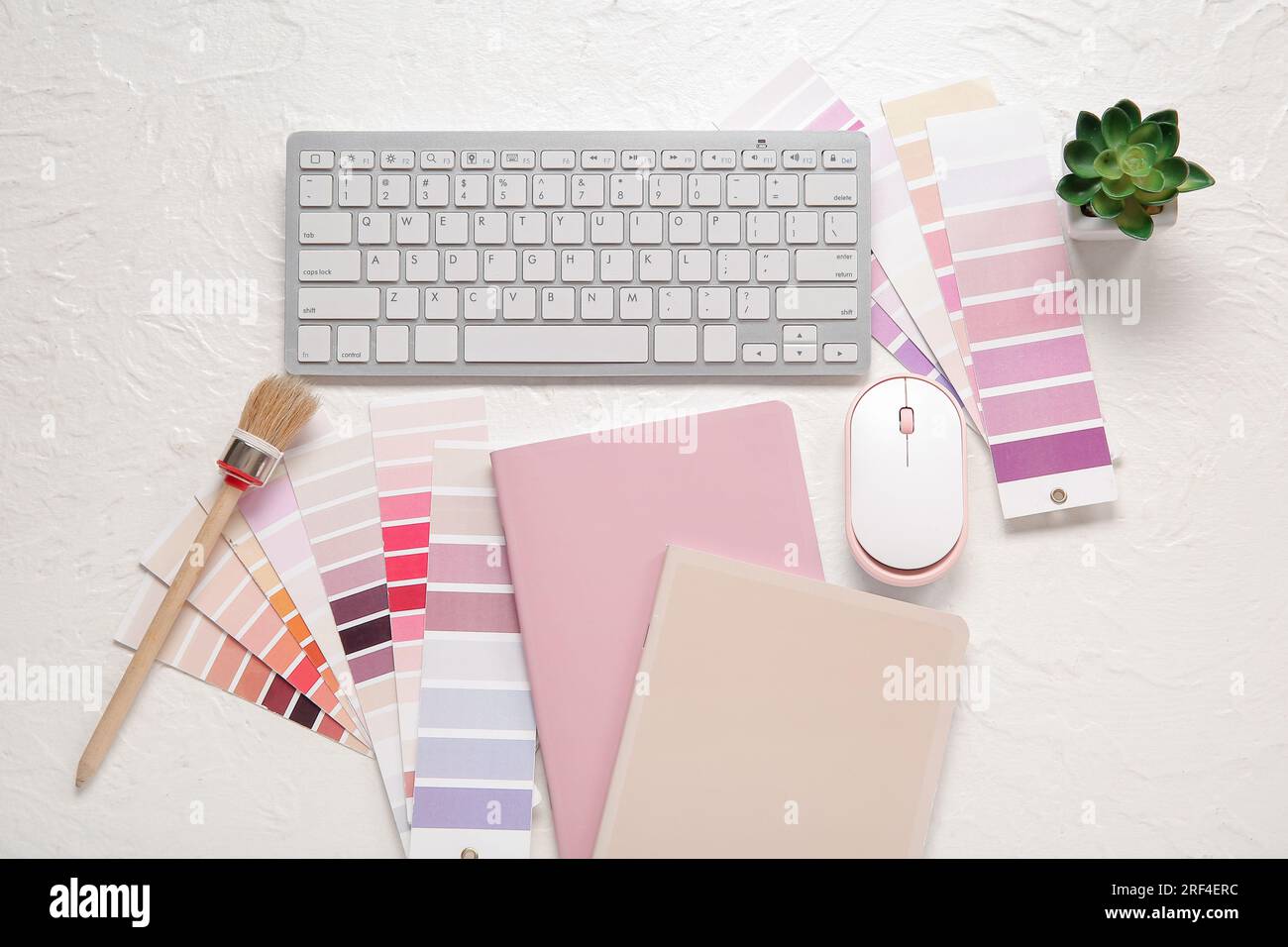 Color palettes, PC keyboard, notebooks and brush on light background ...