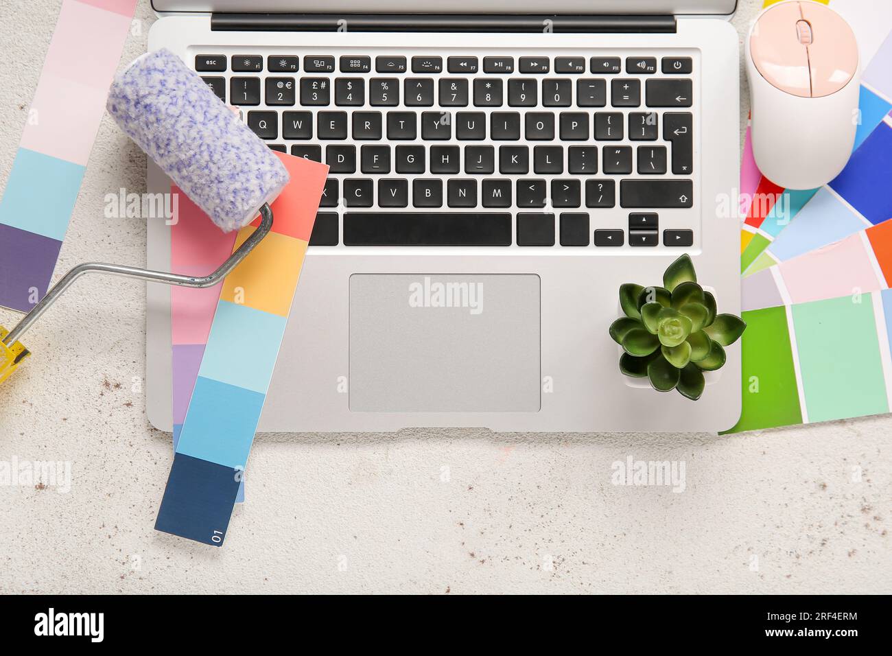 Color palettes, paint roller and laptop on light background, top view ...