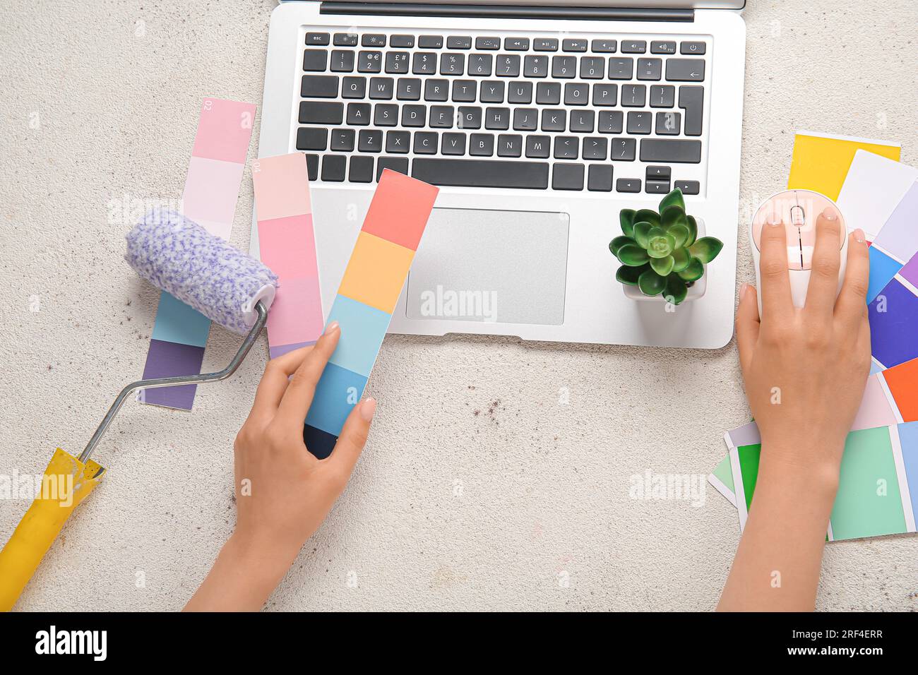 Female hands, color palettes, paint roller and laptop on light ...