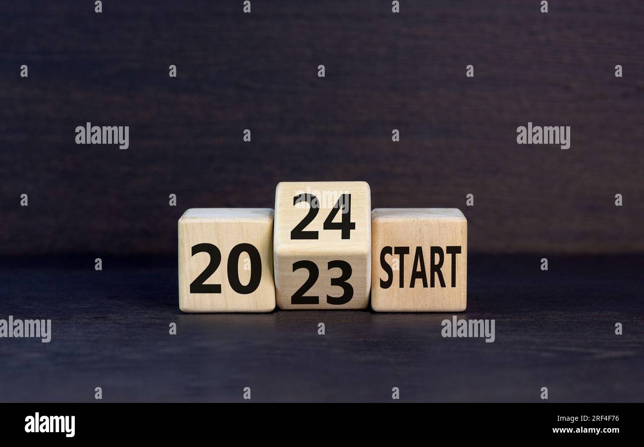 2024 start new year symbol. Businessman turns a wooden cube and changes ...