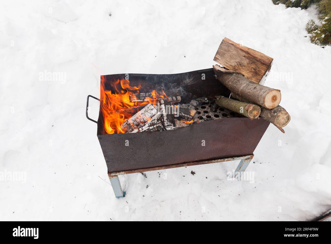 burning logs in the barbecue fire while cooking while relaxing outside ...