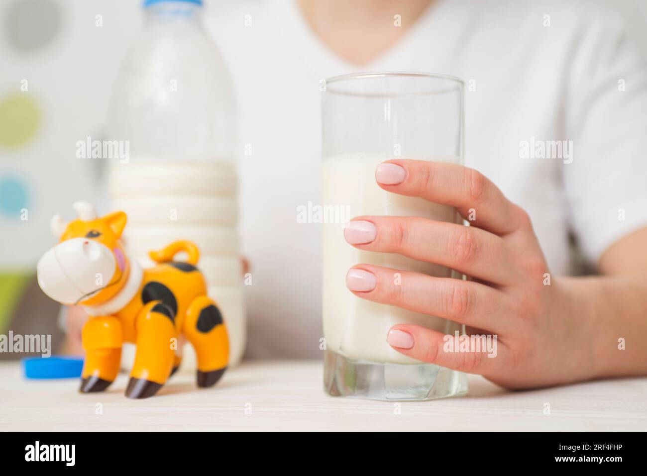 Woman with a glass of milk sits at a white wooden table. Healthy eating ...