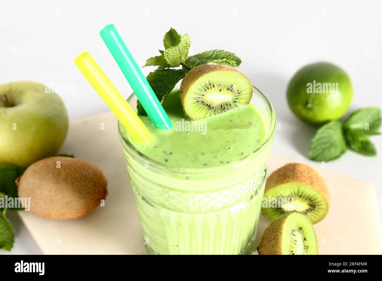 Board With Glass Of Fresh Kiwi Smoothie And Mint On White Background