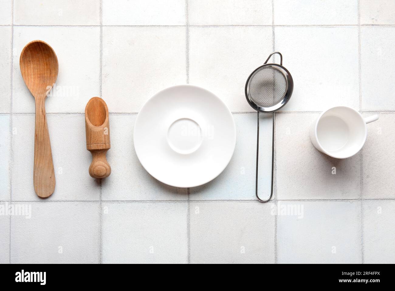 Set of different kitchen utensils on light tile background Stock Photo ...