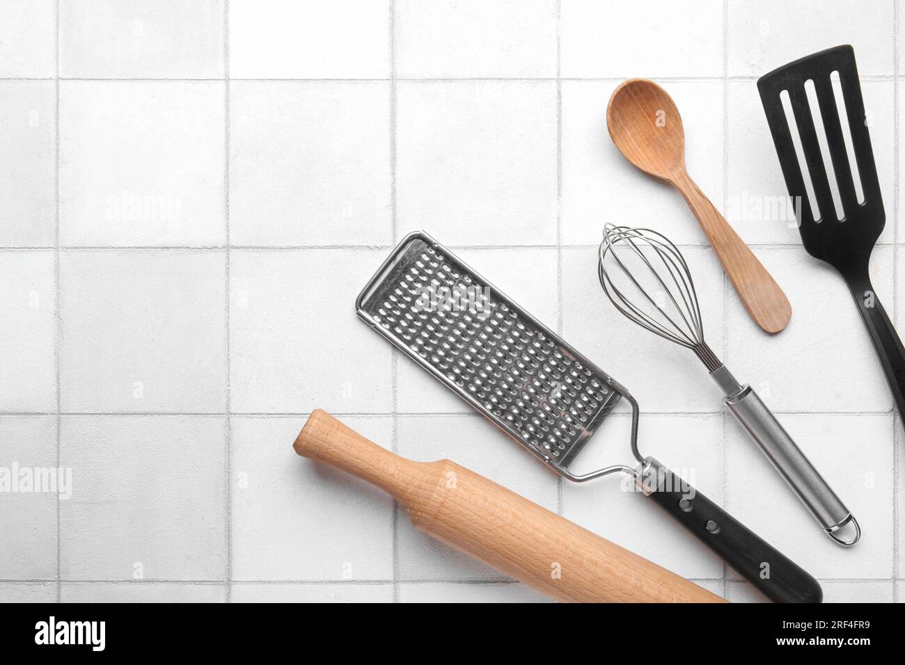 Set of kitchen utensils on light tile background Stock Photo - Alamy