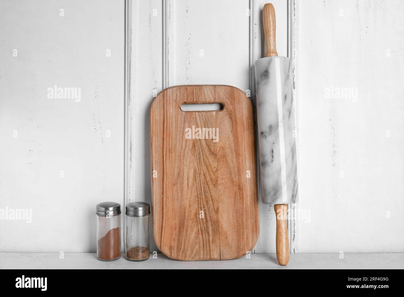 Wooden cutting board, rolling pin and spices on light background Stock ...