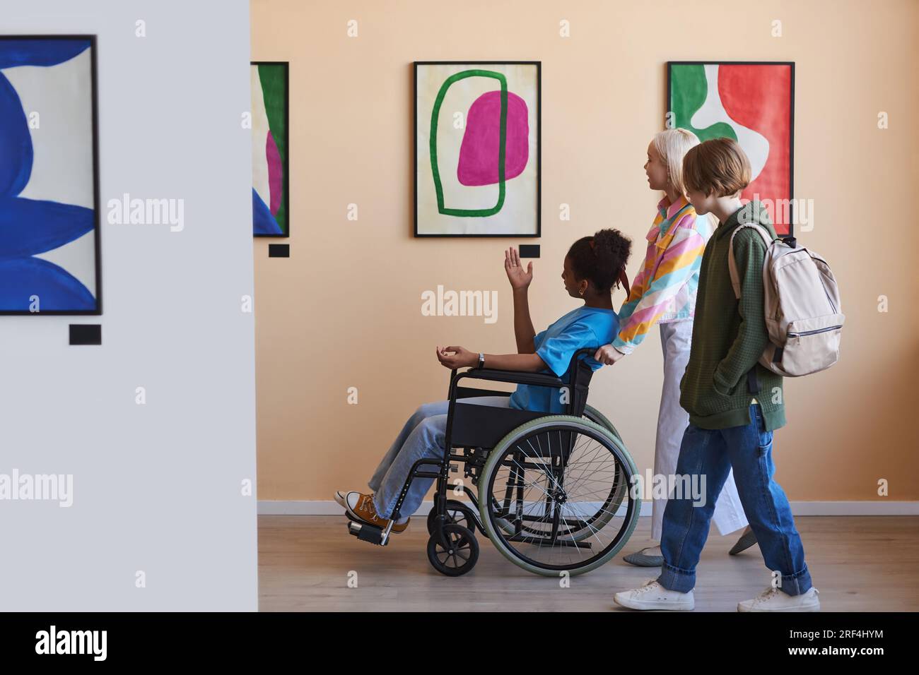 Side view of group of teenagers assisting friend with disability while ...