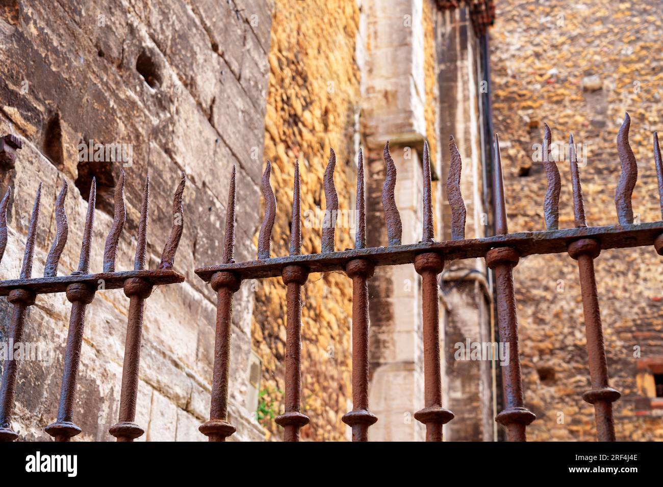 Forged curved sharp spikes of ancient iron fence with rust on antique ...