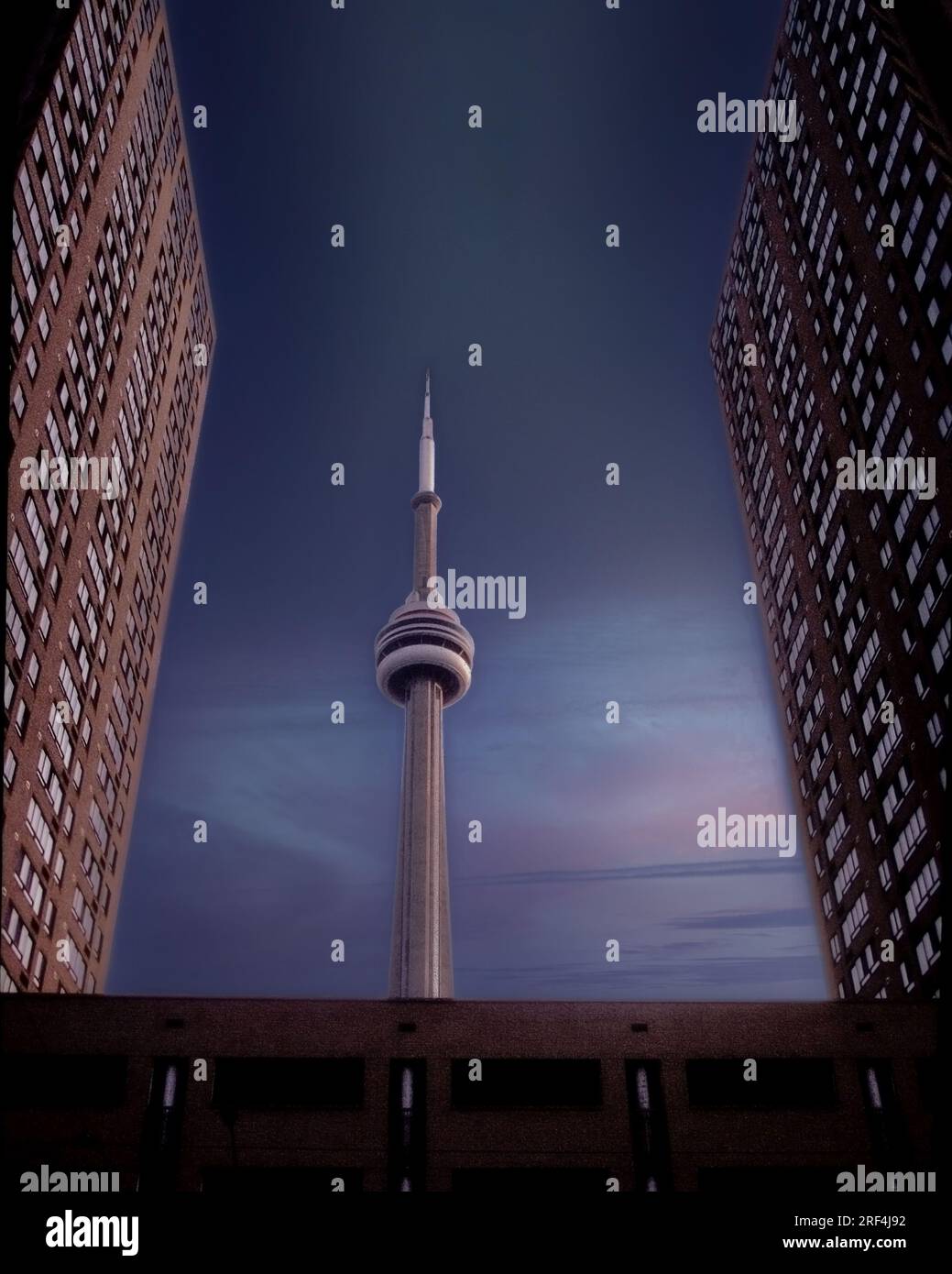 View of CN Tower between two tall buildings at sunset, Toronto, Canada ...