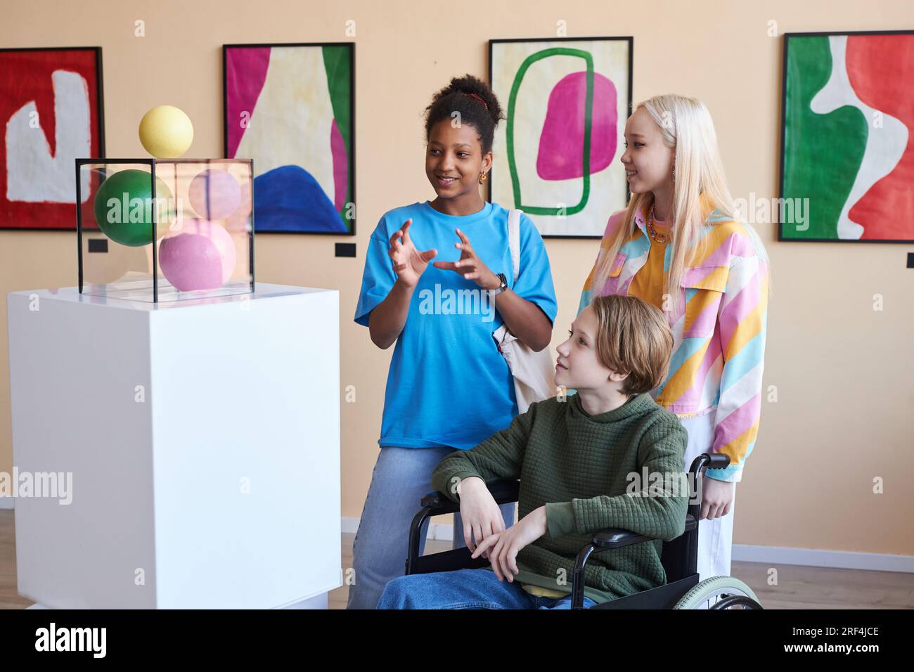 Inclusive group of friends with teen in wheelchair visiting museum ...