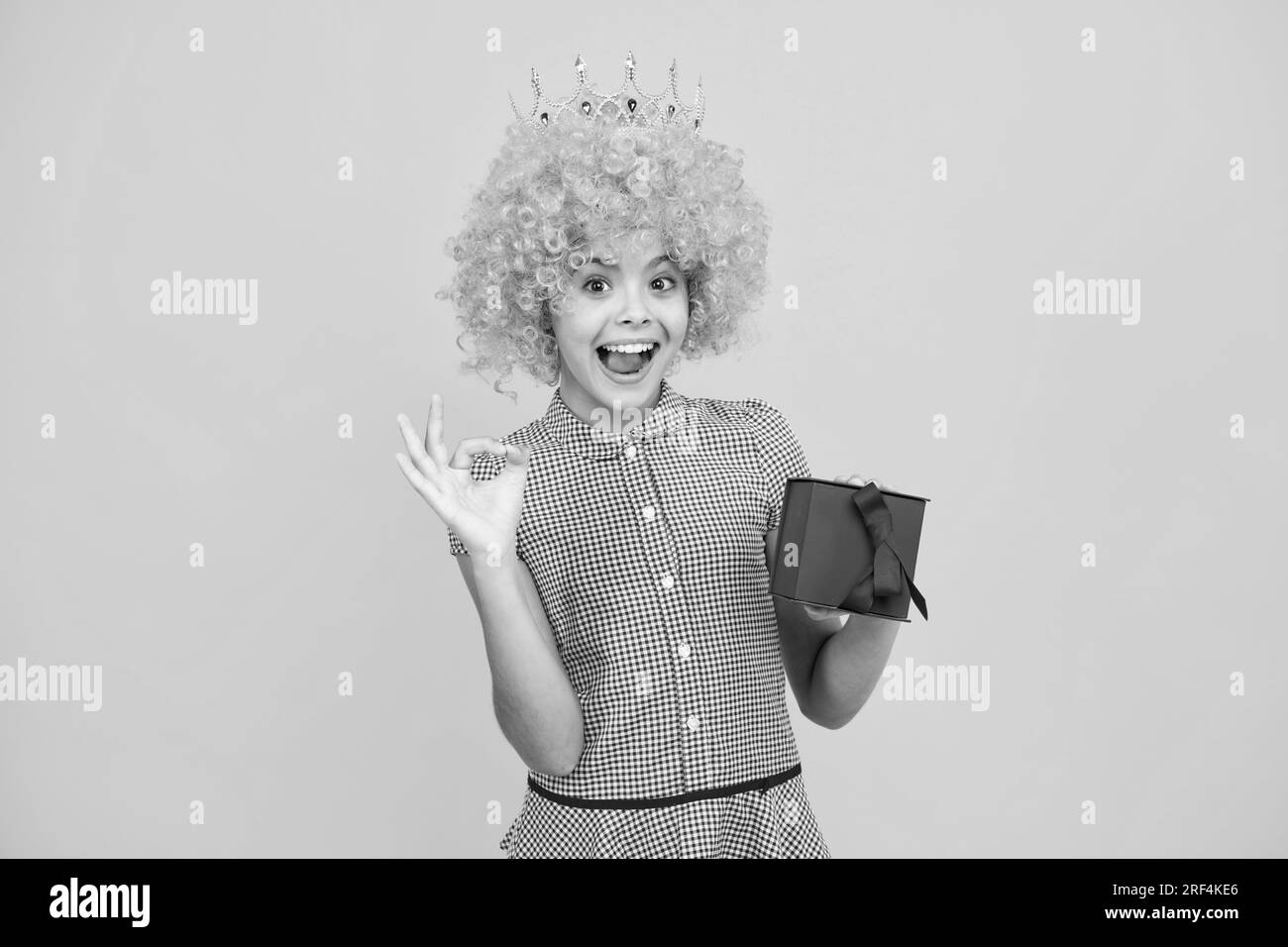 Amazed teen girl. Child with gift present box on isolated studio ...
